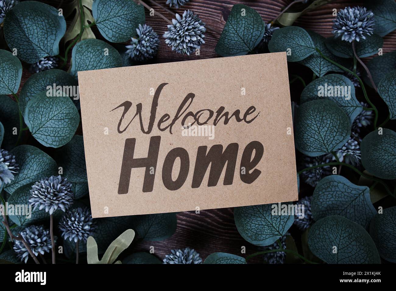 Welcome Home text message on paper card with flowers border frame on ...