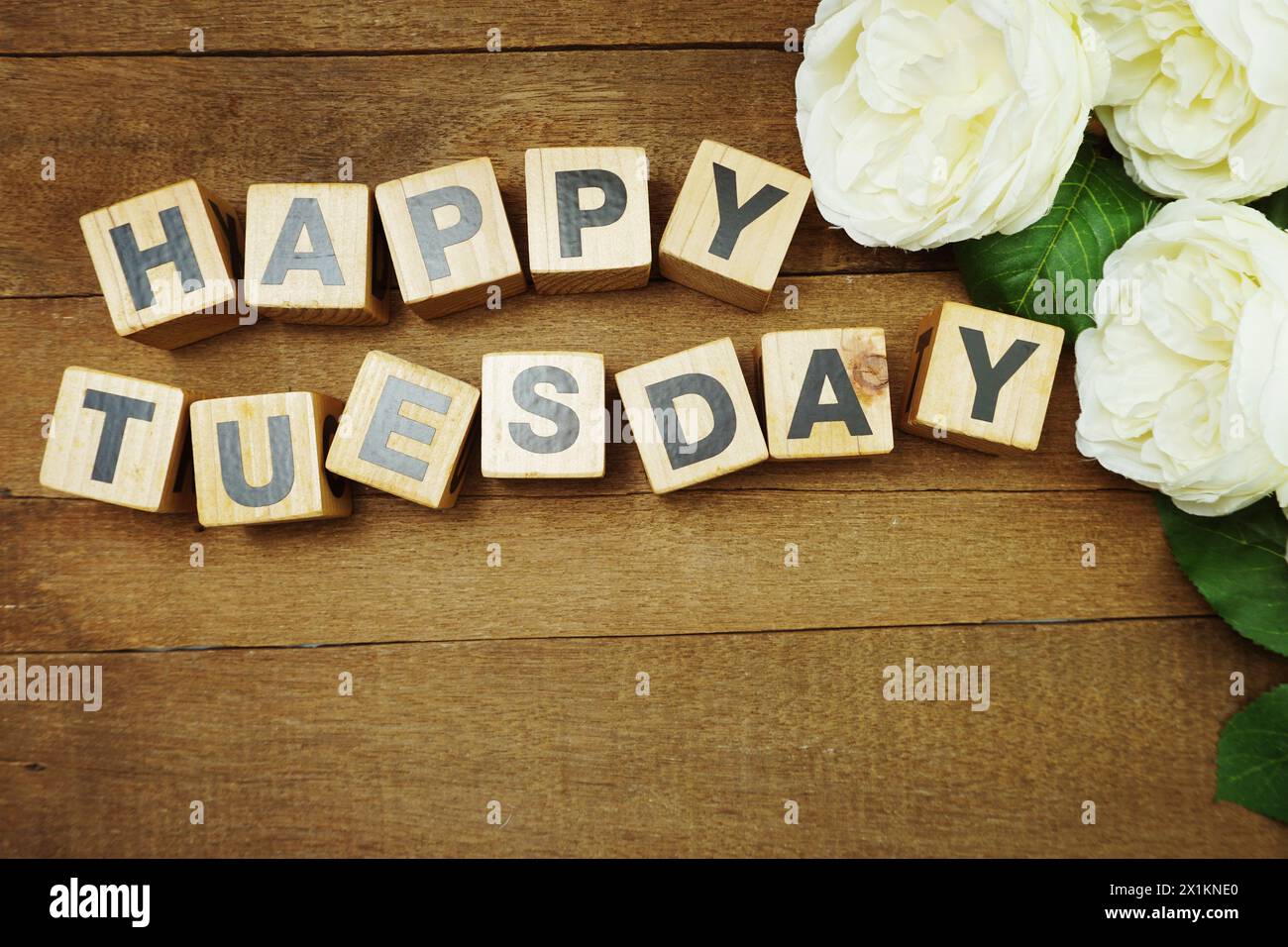 Happy Tuesday alphabet letter with flower bouquet on wooden background ...