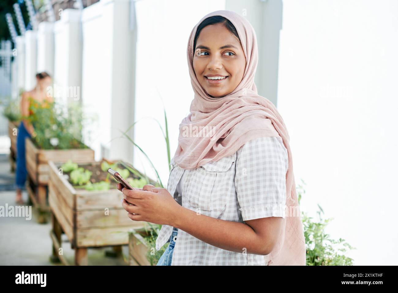 Muslim woman, cellphone and happy in greenhouse for plant research, ecology and social media ...