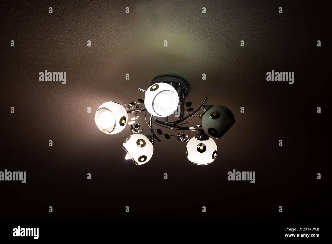 A ceiling fixture adorned with a cluster of stylish metal light bulbs ...