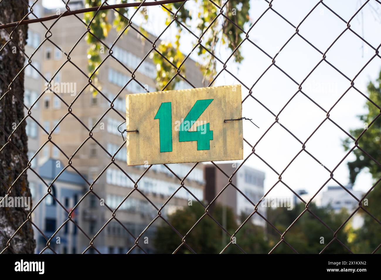 a sign on a chain link fence shows the number 14 High quality Stock ...