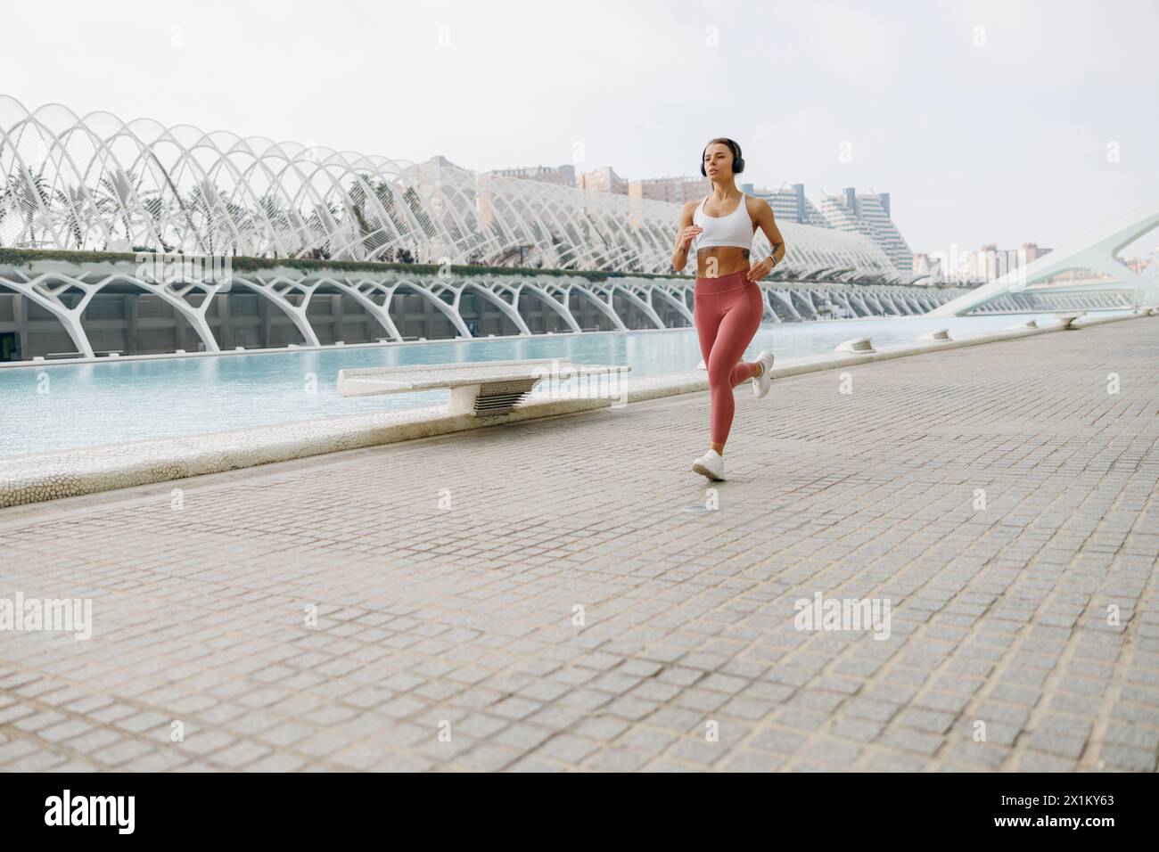 Active woman athlete is jogging on morning on modern building ...