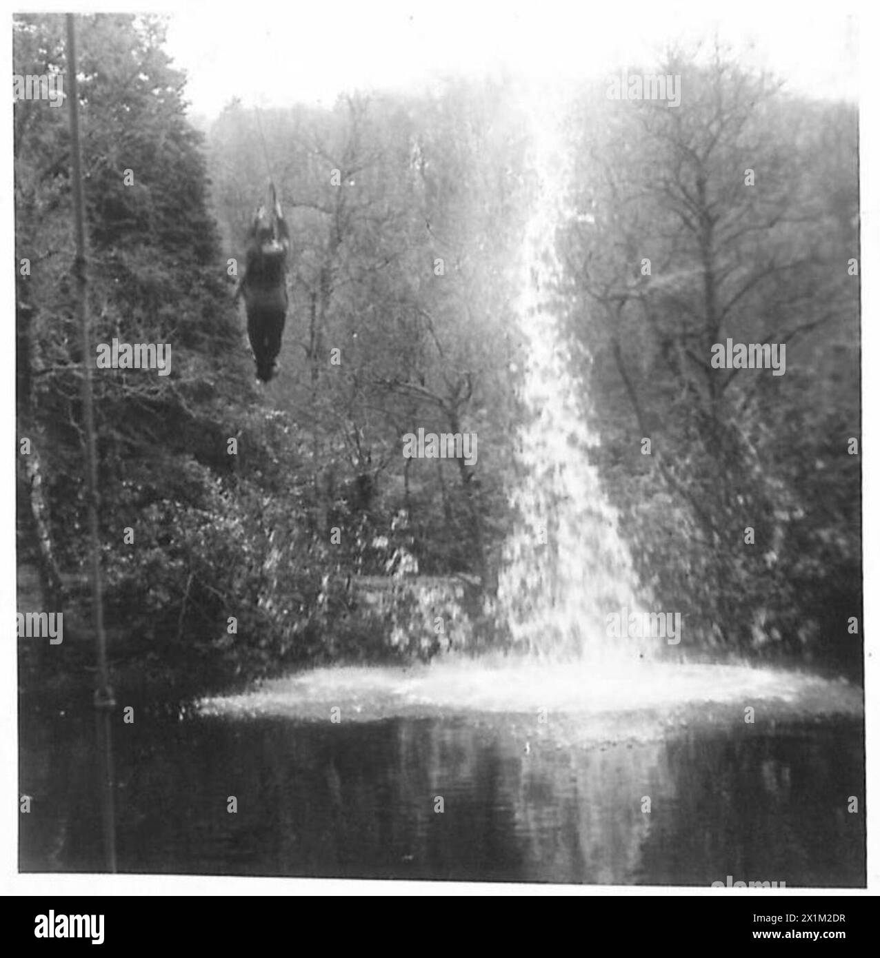 Newspaper correspondents observe commandos crossing a river using a ...