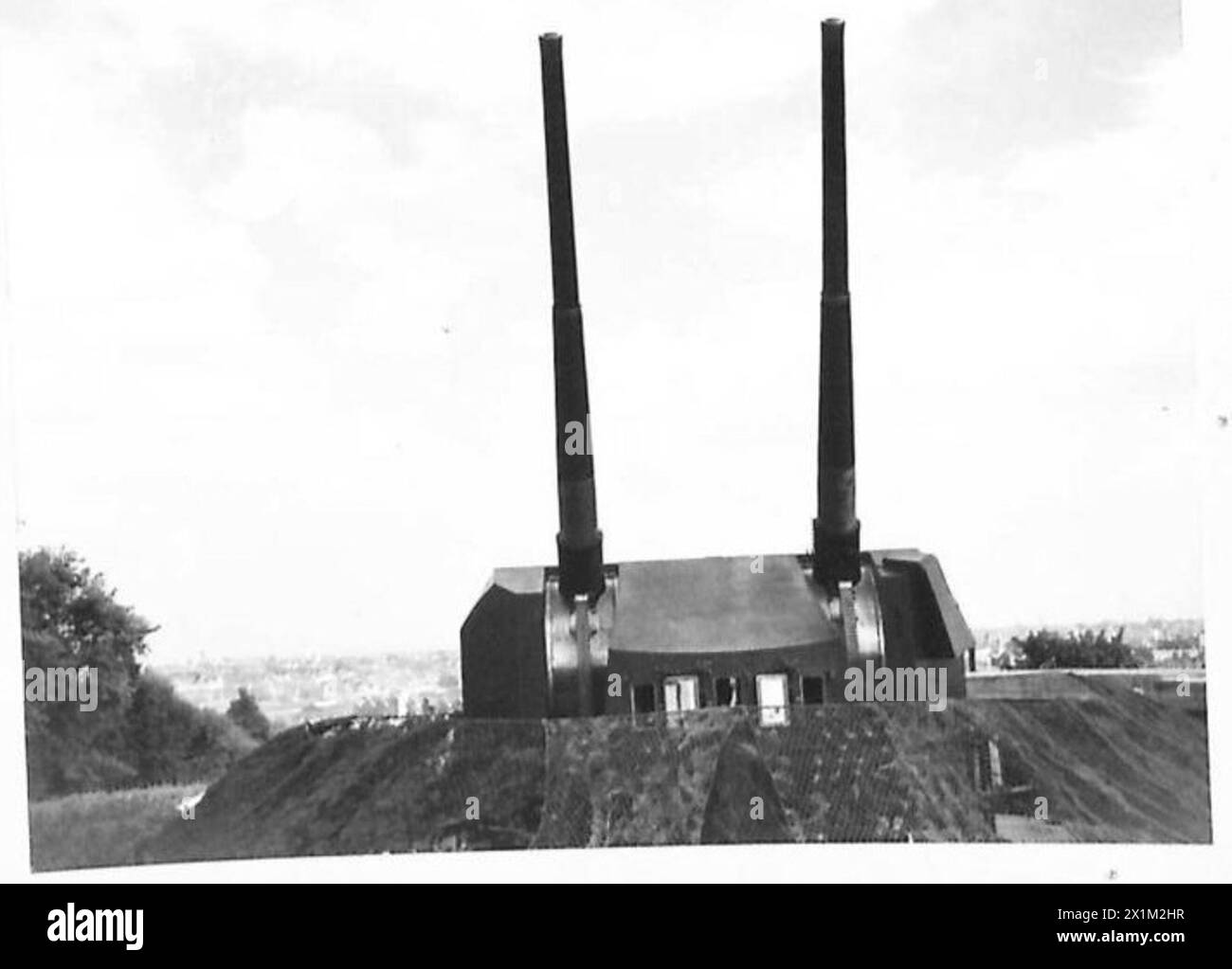 A British Army weapon with twin barrels is shown in an elevated ...
