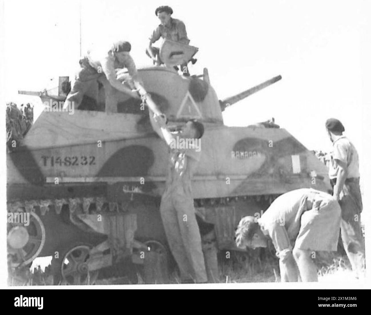 A Sherman tank is loaded with 75 mm shells by British Army personnel ...