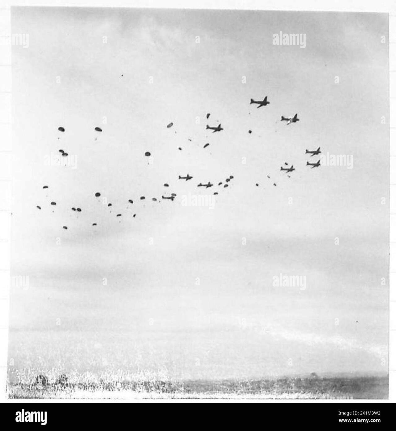 Dakota aircraft fly in formation over dropping zones as paratroops ...