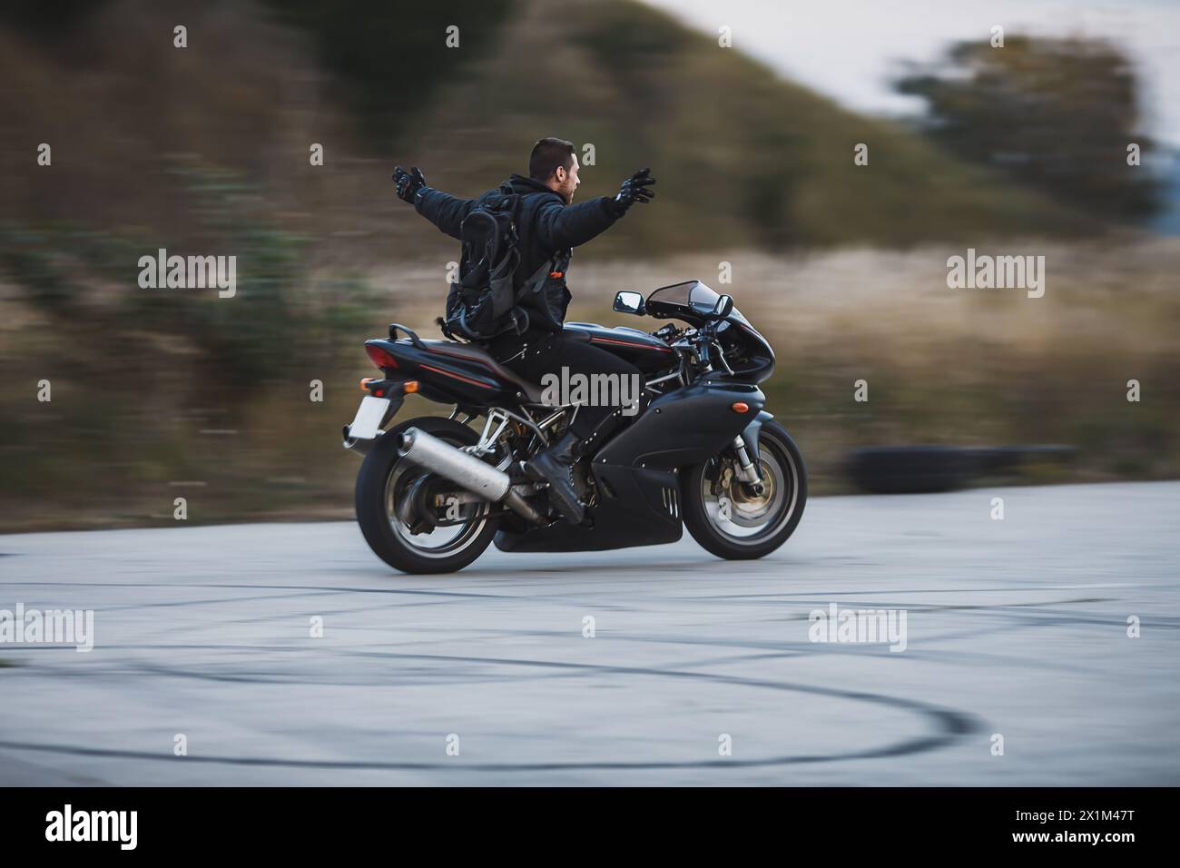 Young biker riding a sport motorbike without hands and feel free ...