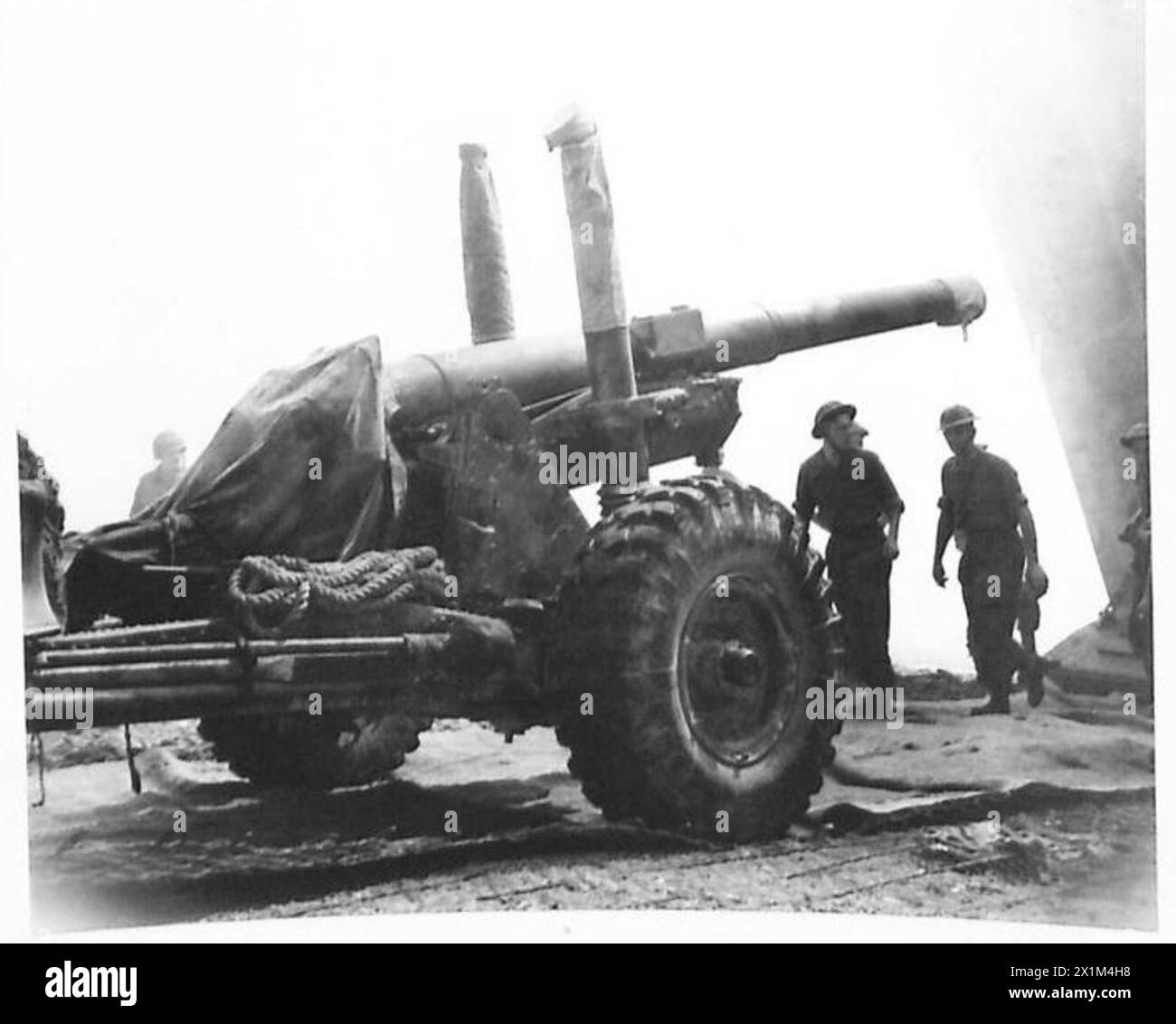 A 5.5 inch medium field gun is unloaded from a Landing Ship Tank (LST ...