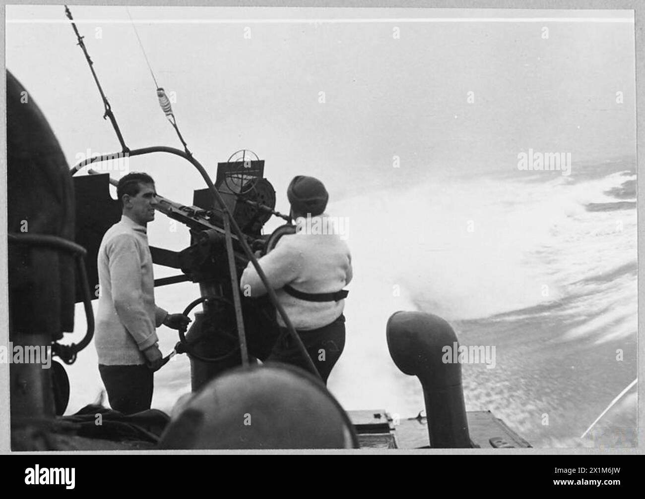 A deck hand gunner operates a 20mm Oerlikon gun on the stern of a High ...