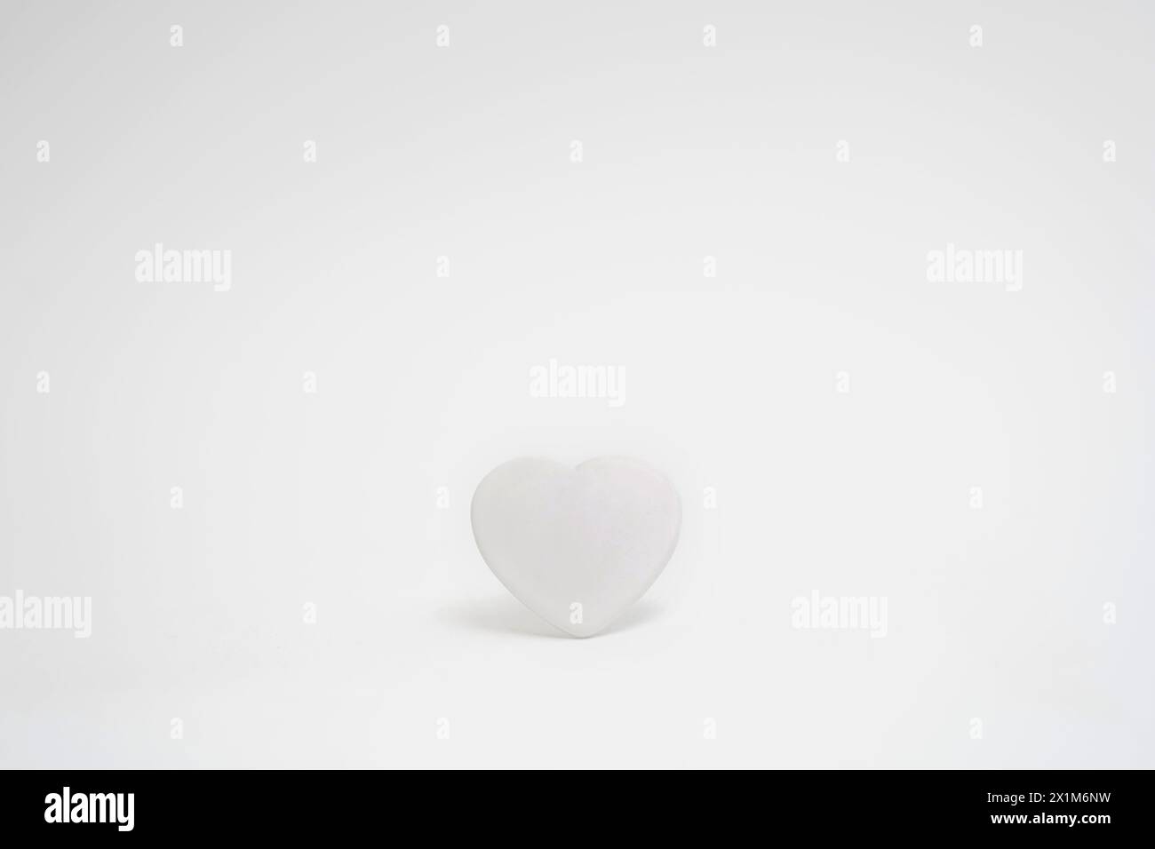 White heart on a white background in the center of the frame ...