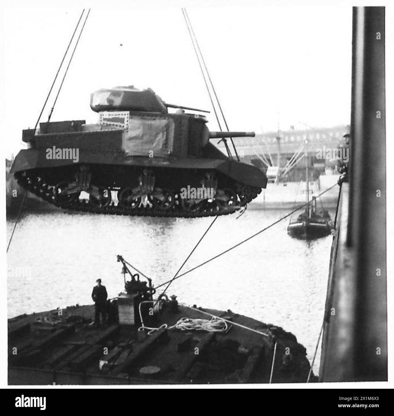 A General Grant tank is hoisted from a ship’s hold during arrival for ...