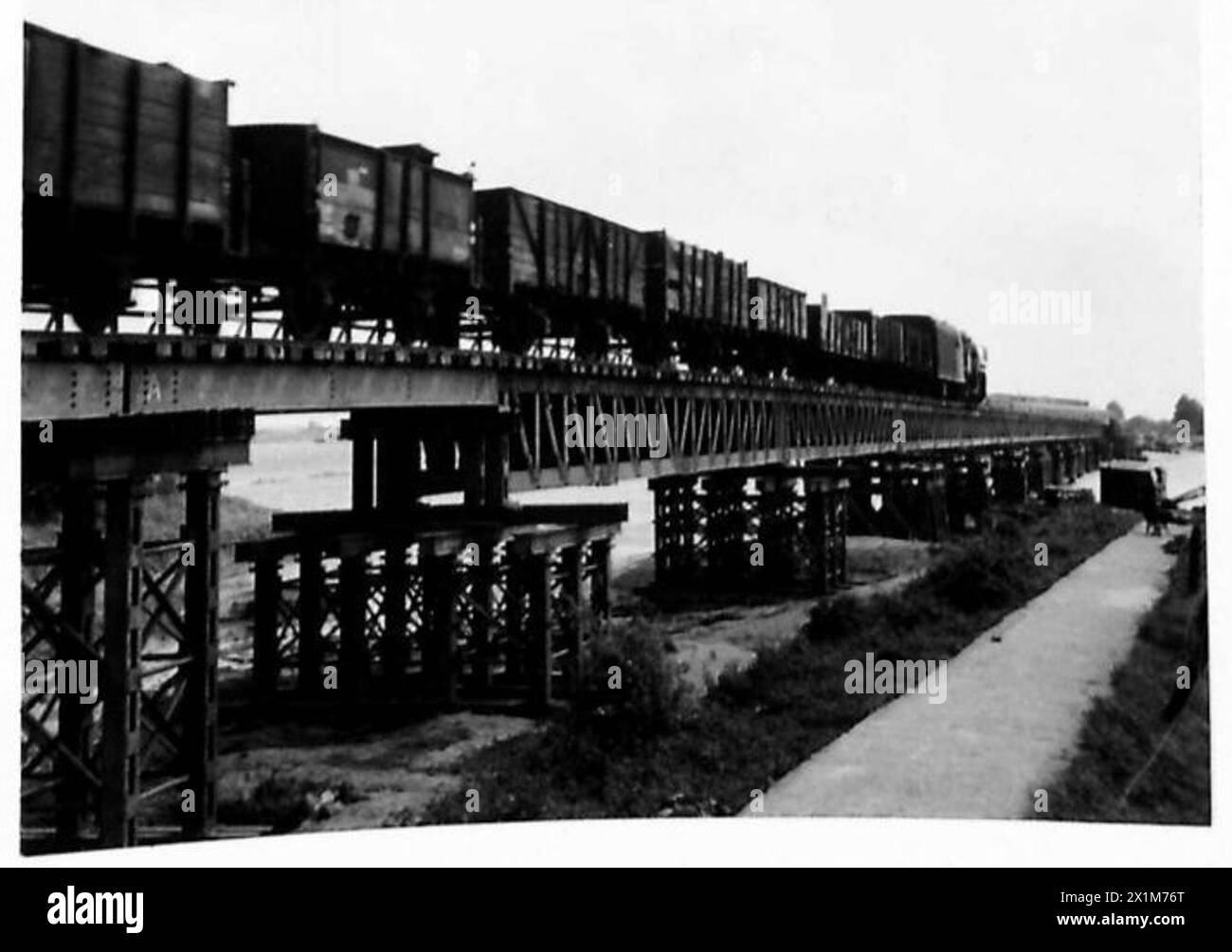 A train carrying military supplies passes over a permanent bridge ...