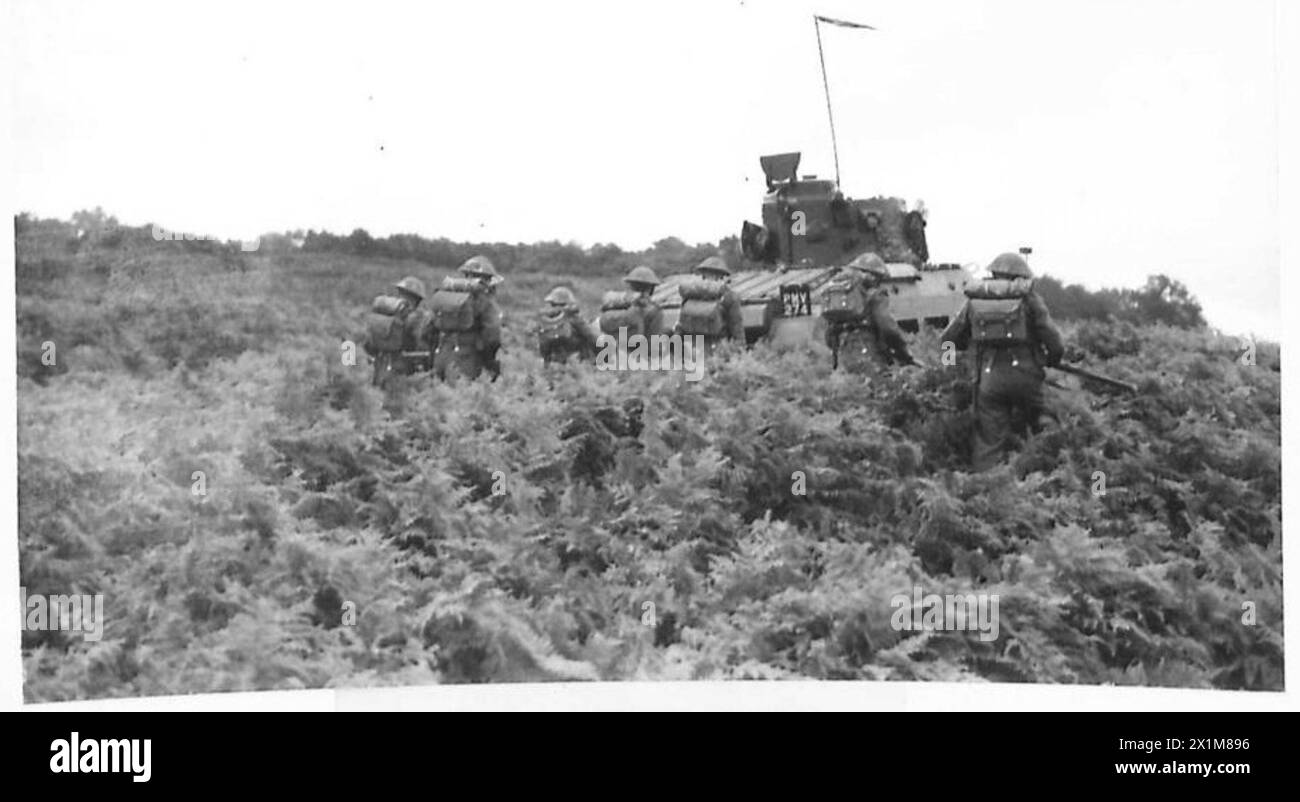 Infantry advance behind tanks during a combined exercise with artillery ...