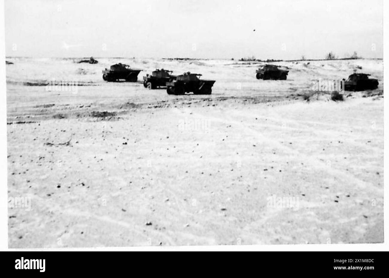 TANKS IN ACTION - Scout cars travelling over the sand dunes engaged in ...