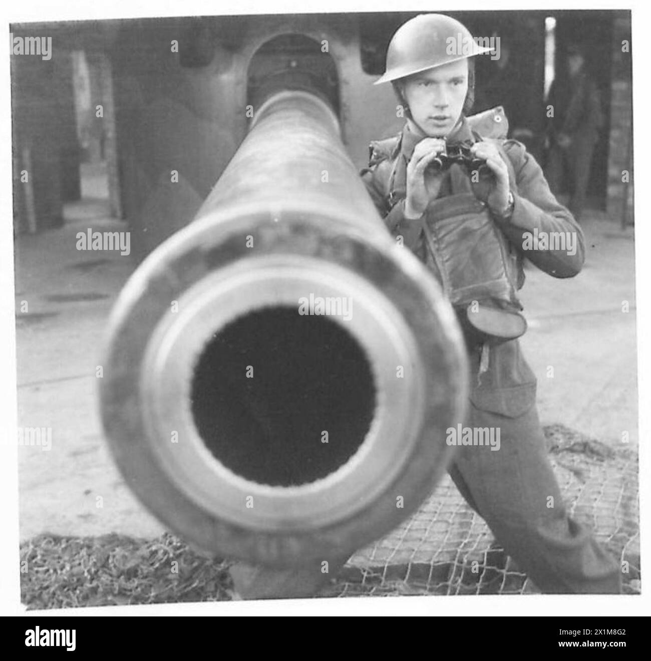 A Scottish gunner stationed beside an artillery gun, maintaining ...