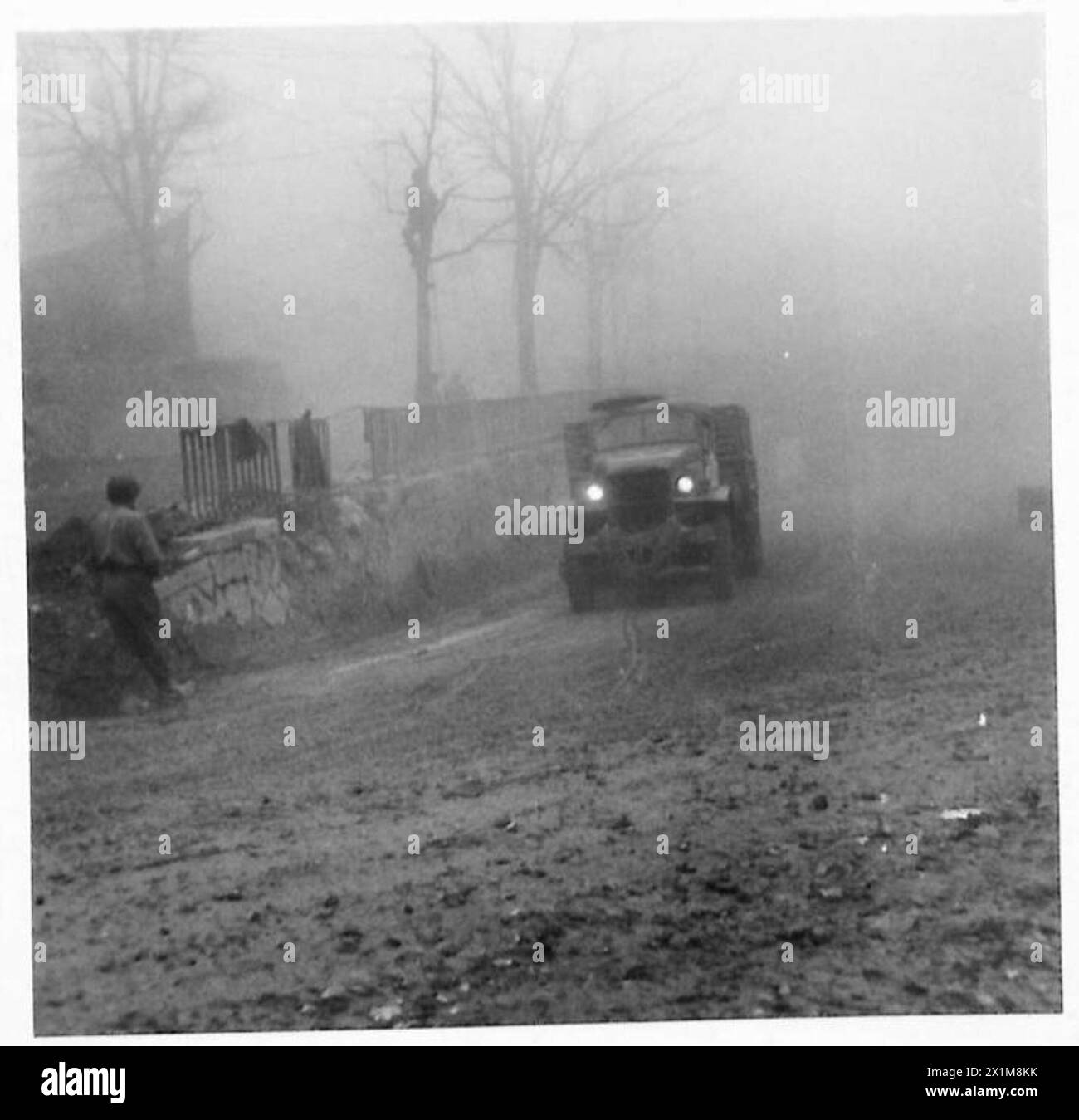 Trucks and jeeps of the British Fifth Army move through thick mist with ...