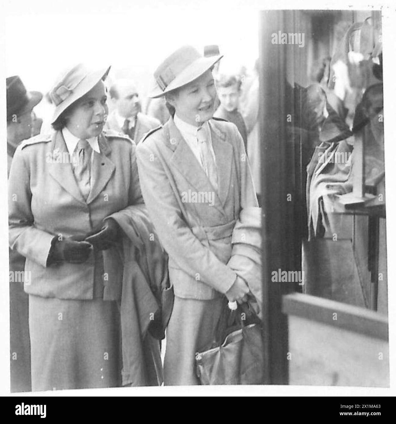 Nursing Sisters Kay Allen and Mrs. Bloor examine fashions in shops ...