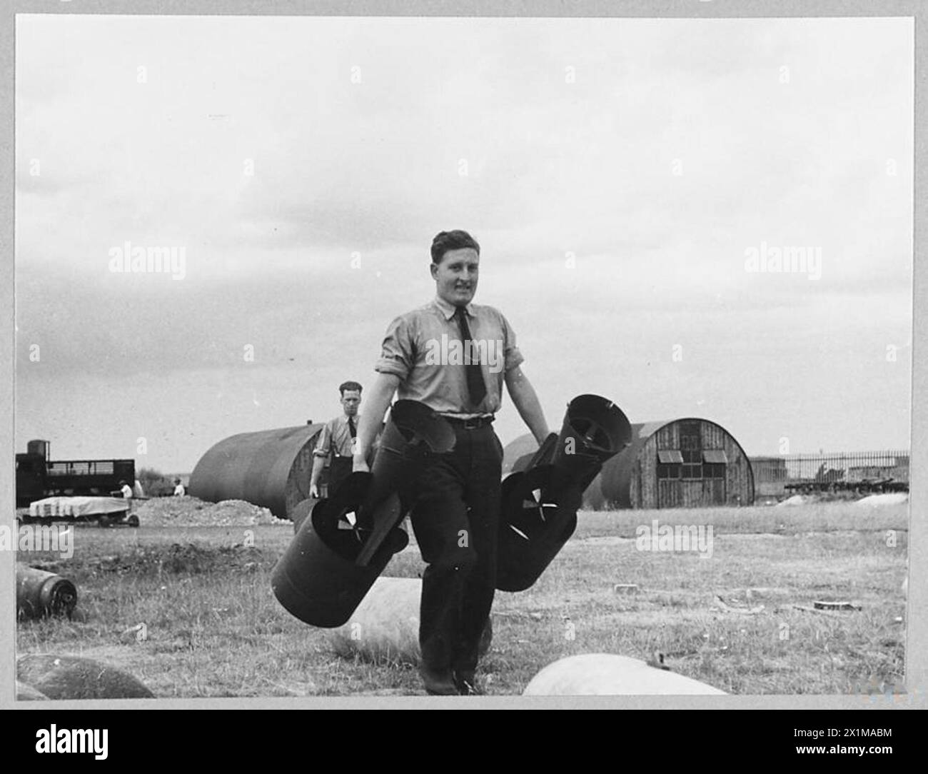 RAF ground staff are shown handling tail fins for bombs at the bomb ...
