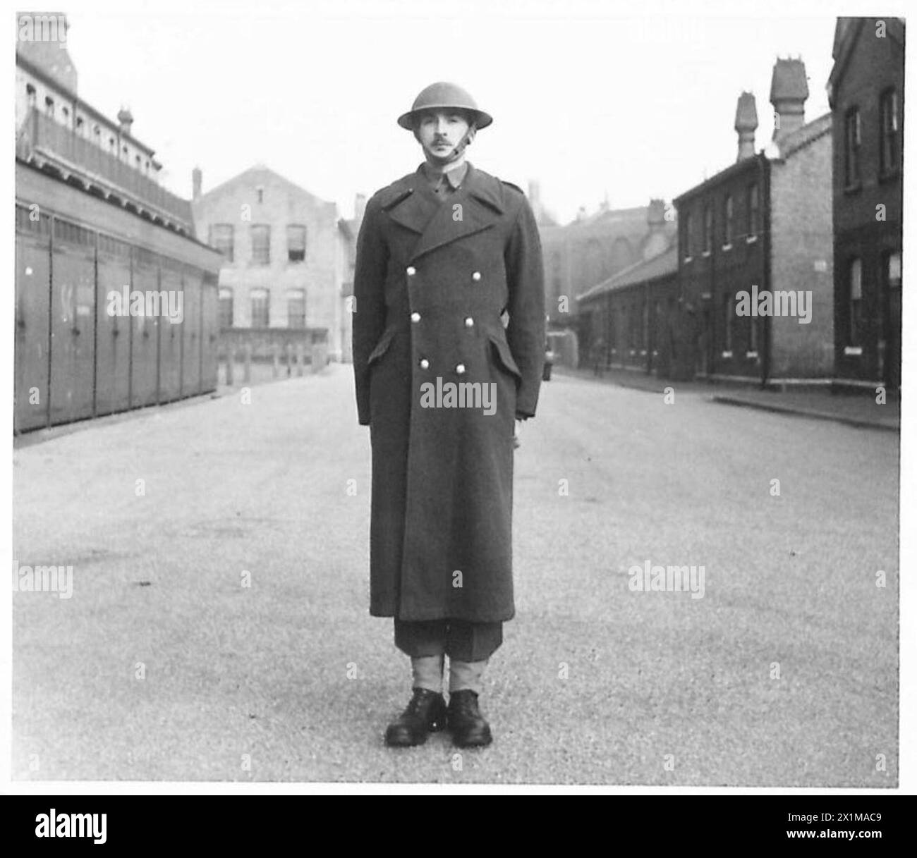 A soldier wearing a greatcoat, steel helmet, anklets, and boots, shown ...