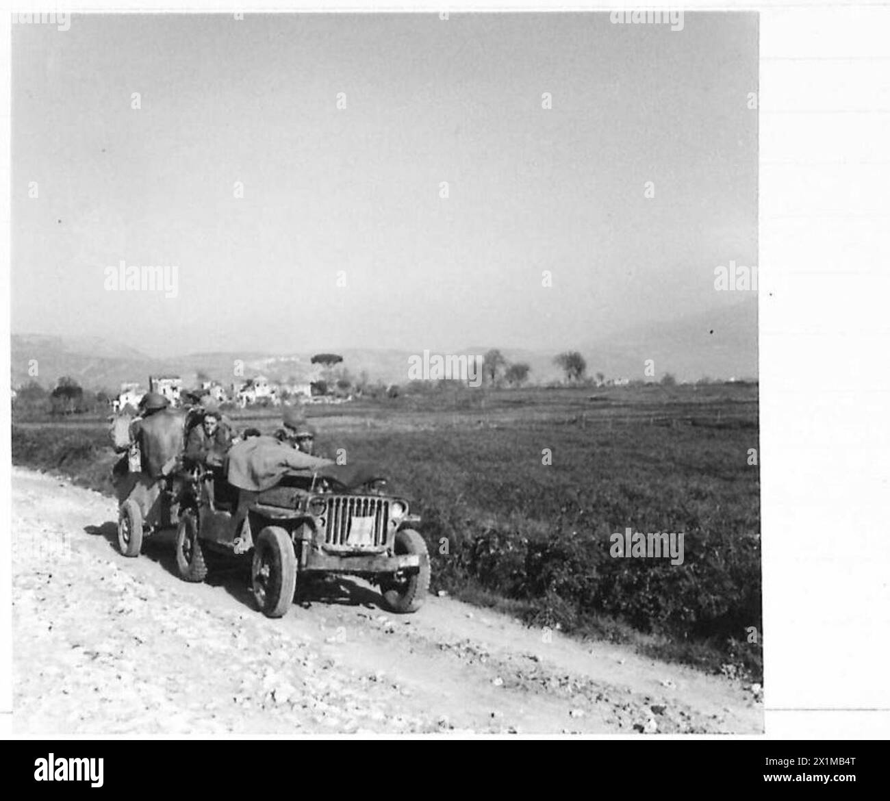 A Jeep carrying wounded soldiers moves to the rear during British Fifth ...