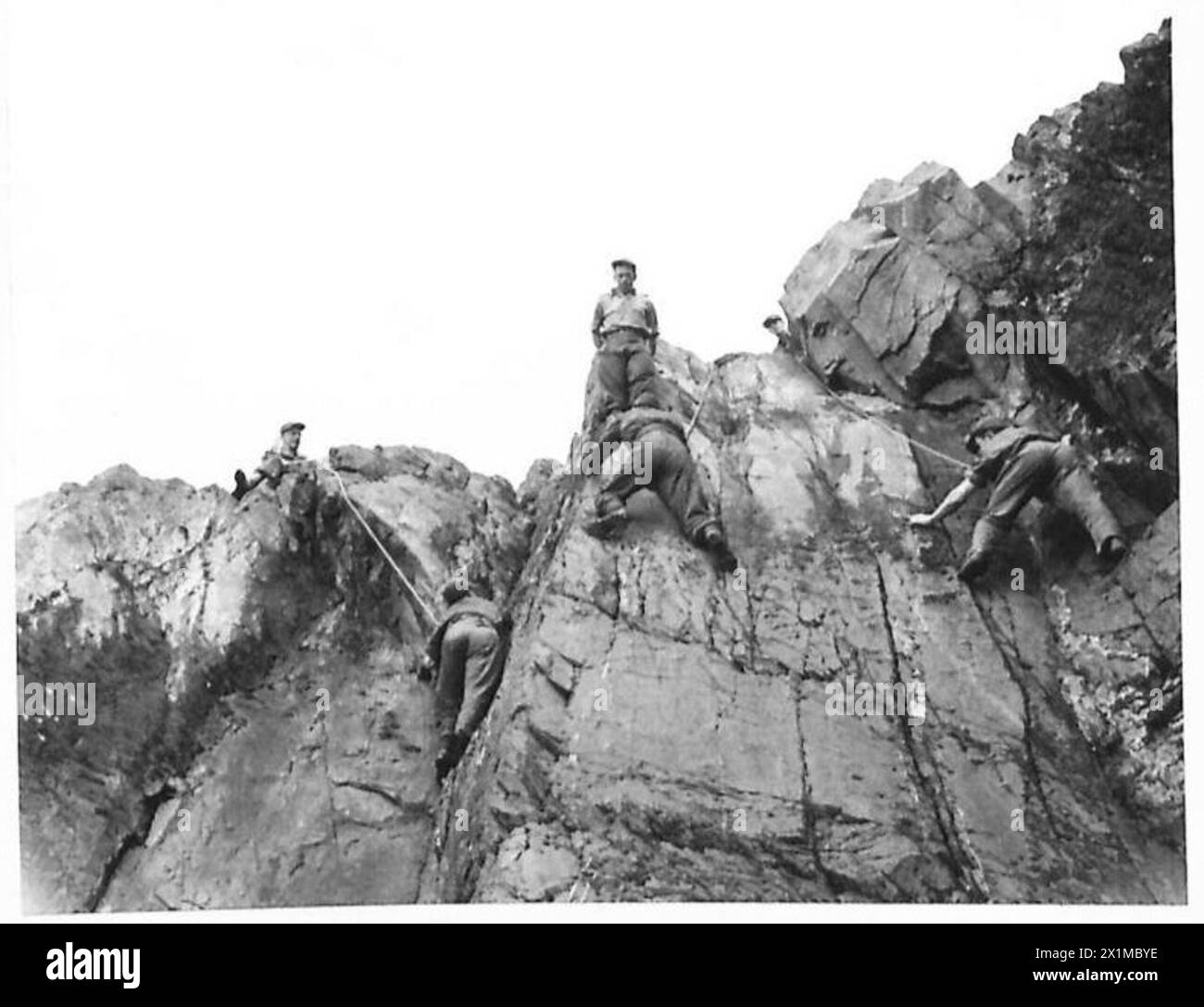 Soldiers of the British Army reach the summit of a cliff during a ...