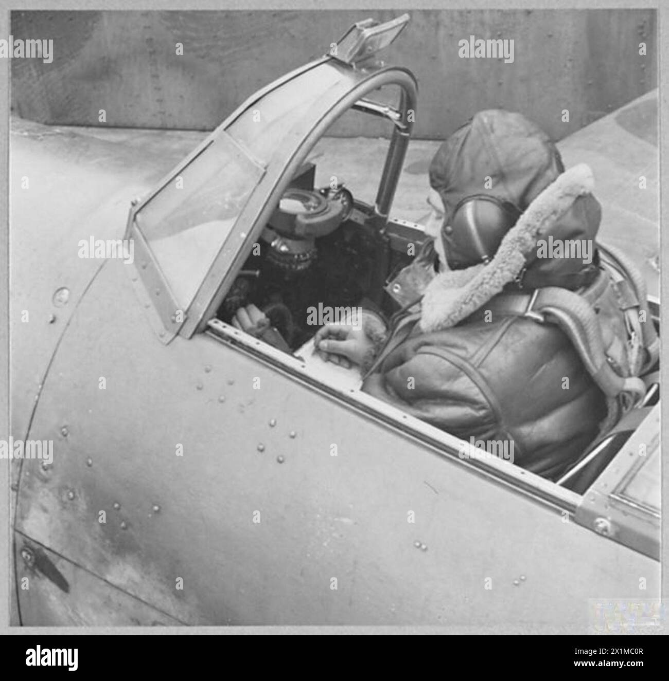 A Royal Air Force flight lieutenant records notes in the cockpit during ...
