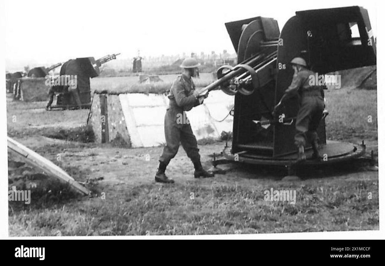 A Home Guard soldier loads a rocket into an anti-aircraft gun projector ...