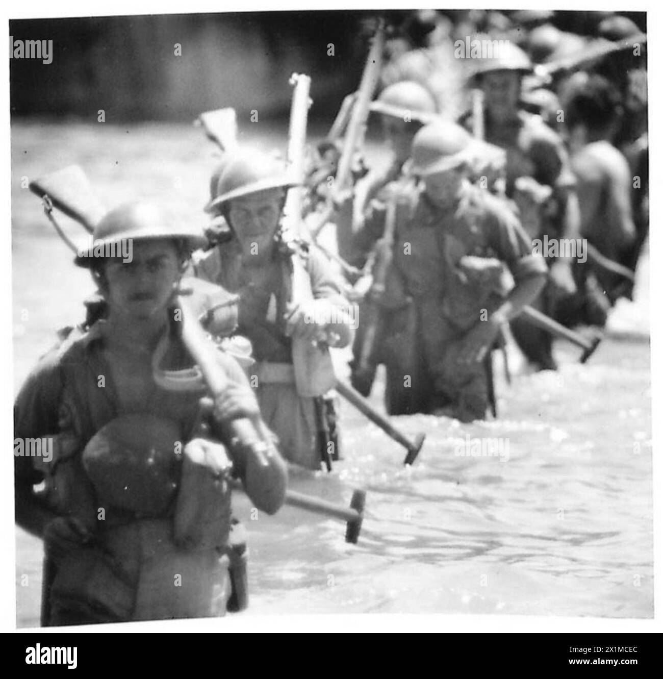Infantry troops wade through shallow waters during the initial stages ...