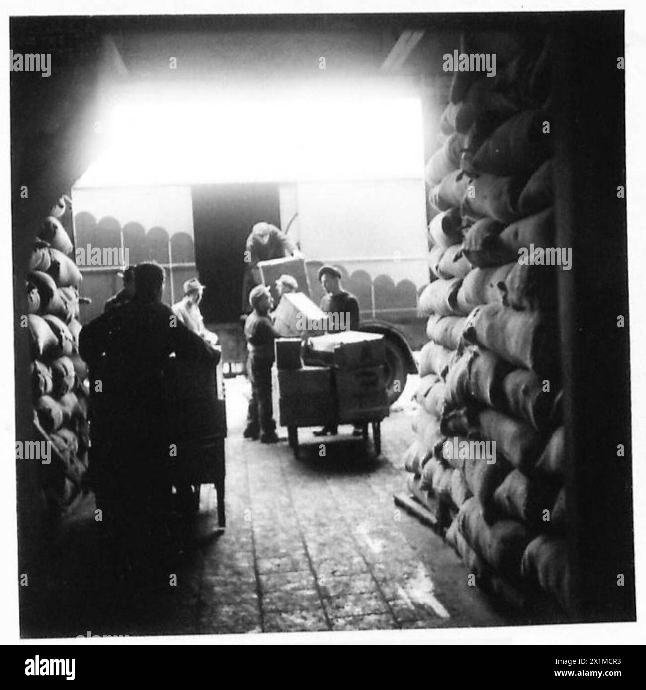 FEEDING LIBERATED HOLLAND - Dutch lorry being loaded with bulk stores for distribution to shops ...