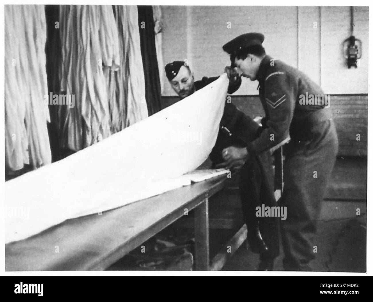 BRITAIN'S PARACHUTE TROOPS IN TRAINING - Each man has to fold and pack ...