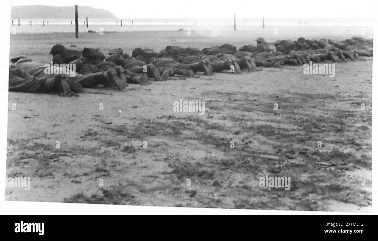 Troops lie prone on sand during live-fire exercises at a weapon ...