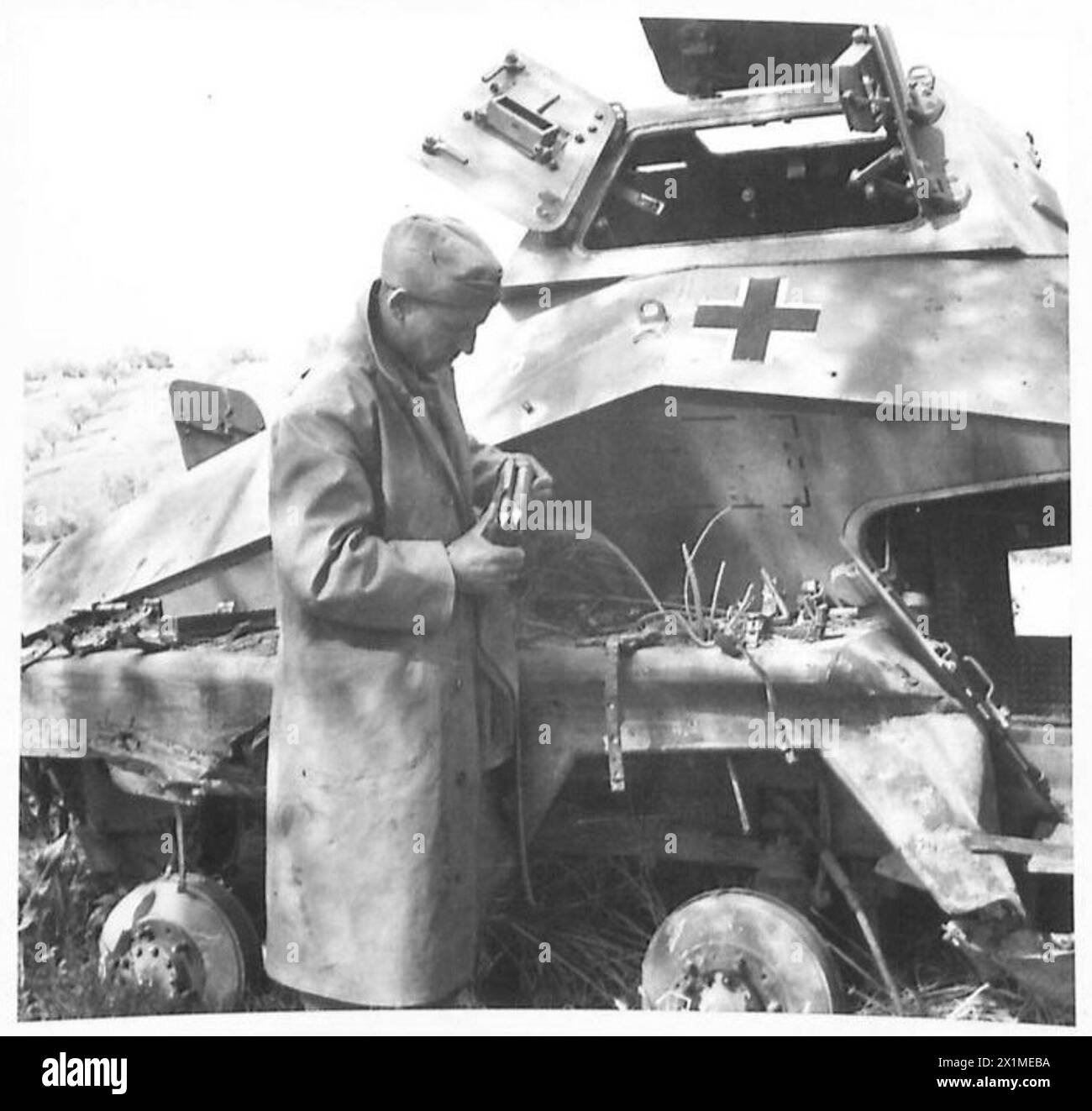 A British soldier inspects the 20mm magazine of a knocked-out German 8 ...