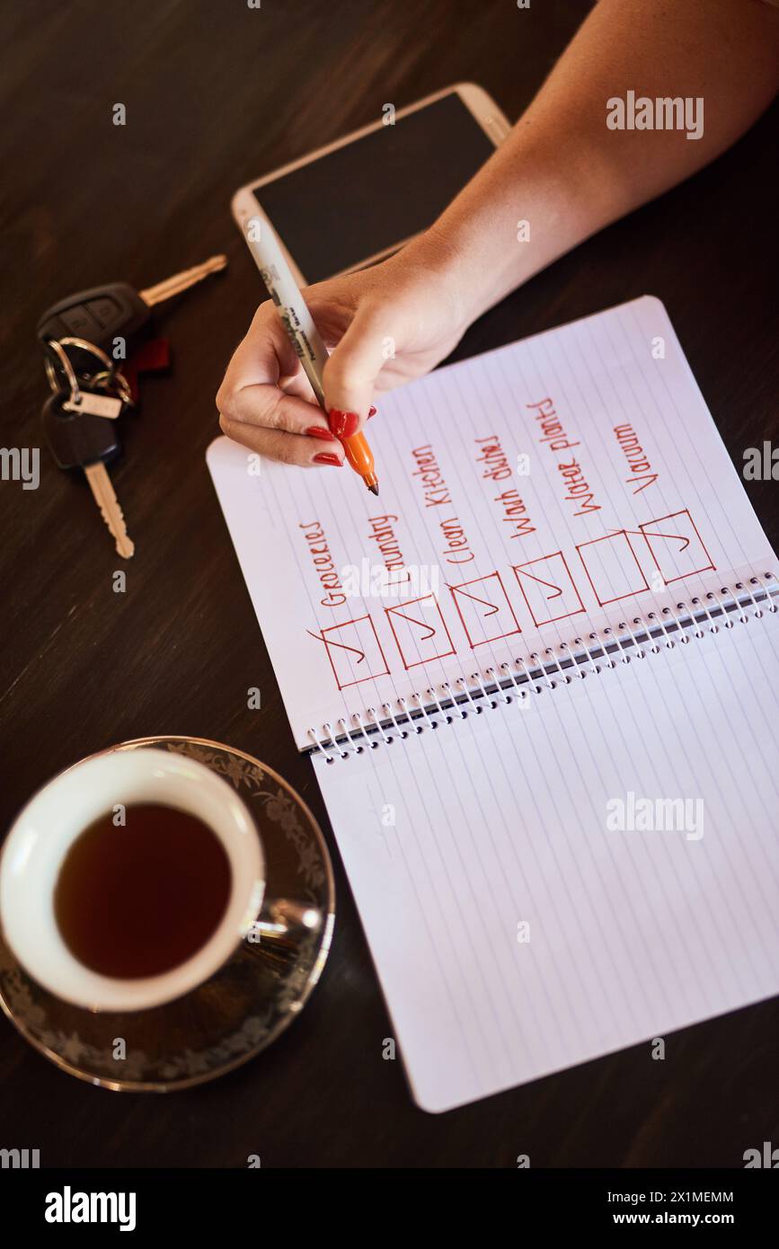 Person writing, tick or hands with notebook and schedule for daily ...