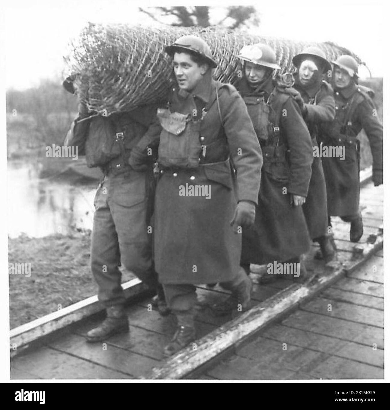 Sappers carry and lay Army track across a river to create a passage for ...