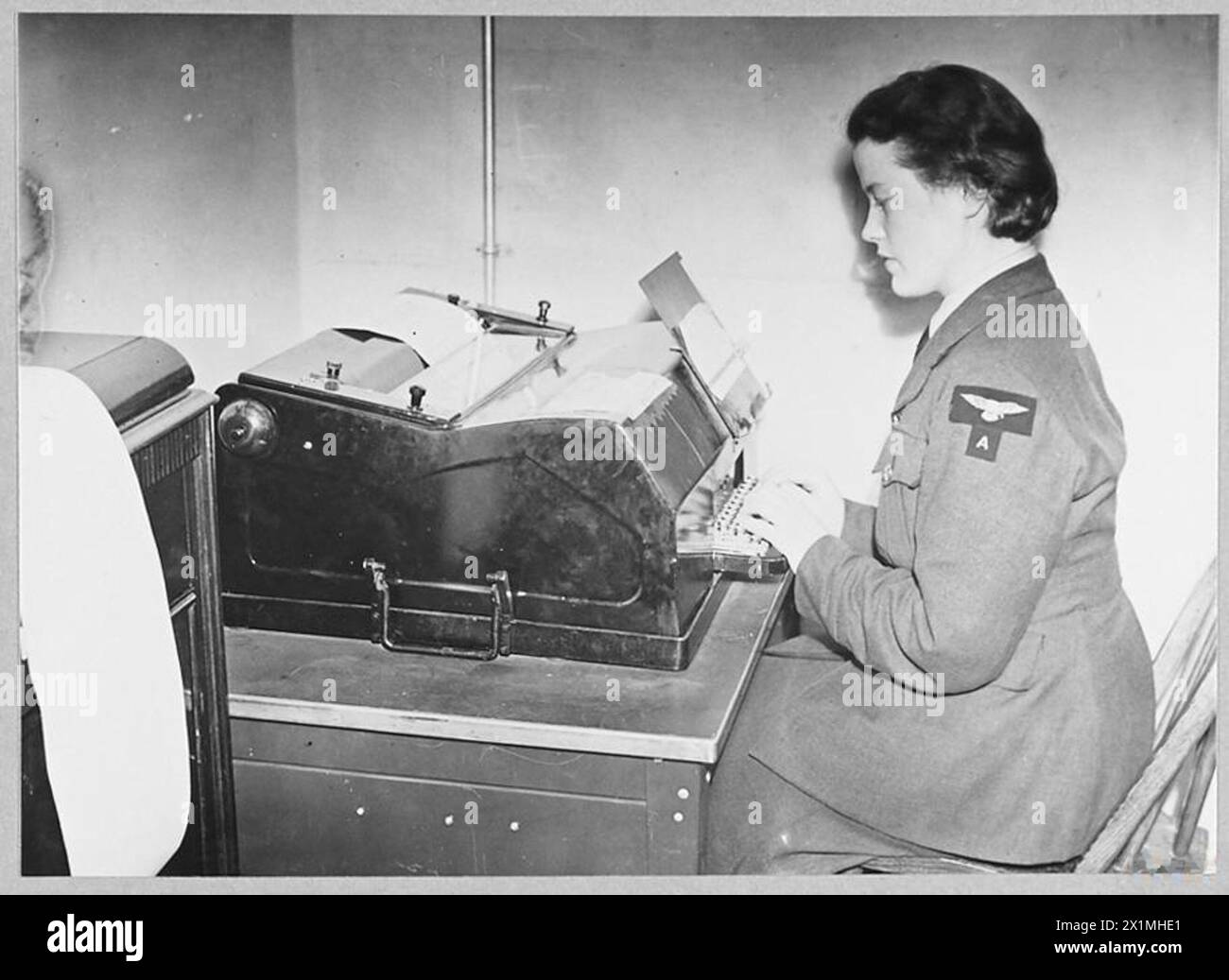 A W.A.A.F. teleprinter operator transmits messages for the Royal Air ...