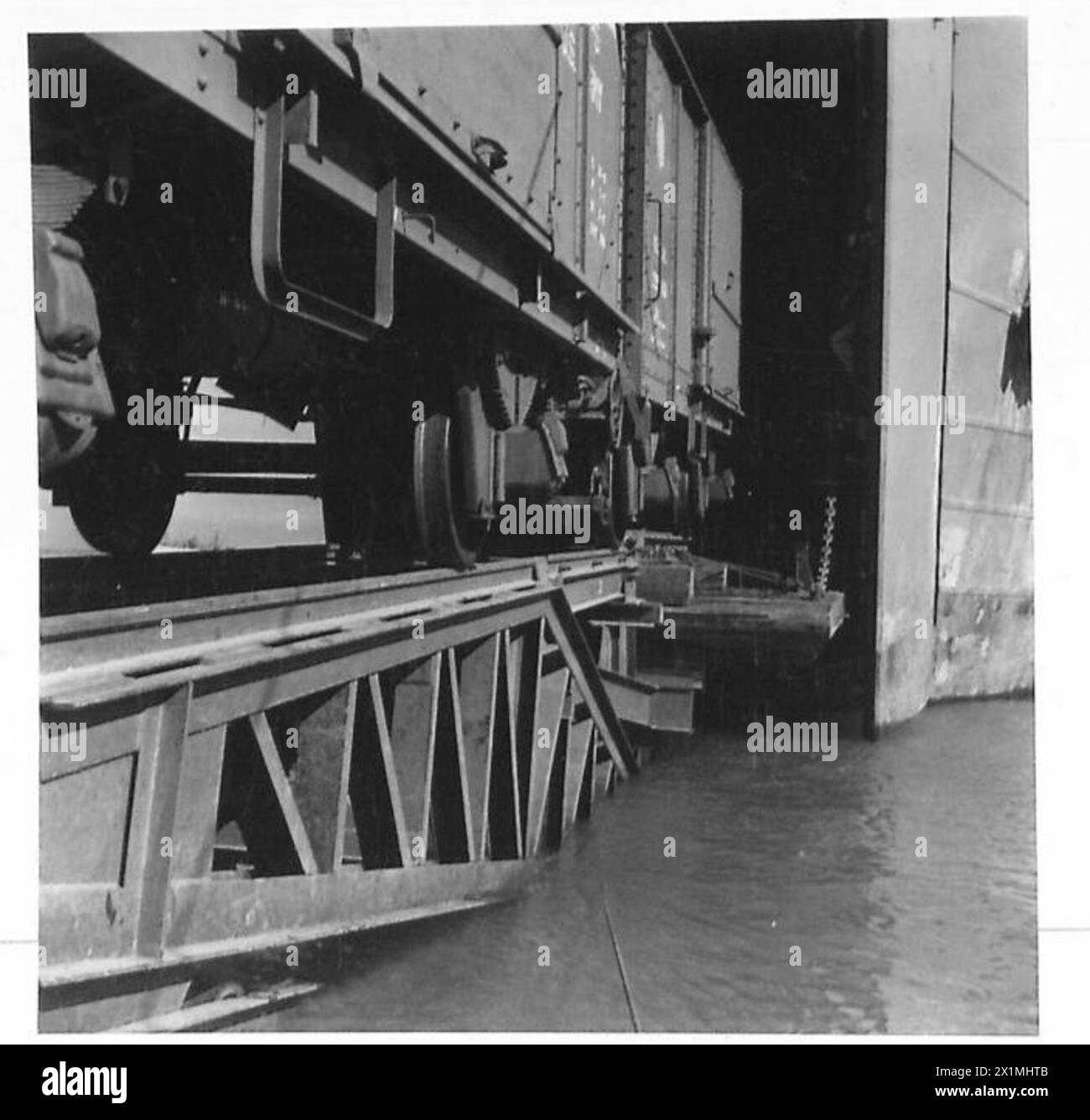Rail wagons are unloaded from a Landing Ship Tank as part of the British Army 21st Army Group ...