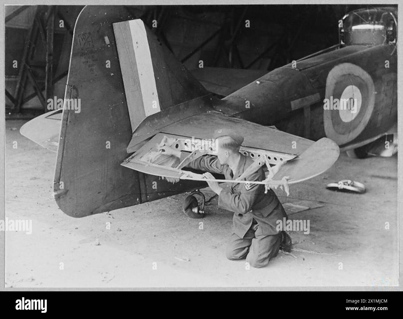 RAF FIGHTER COMMAND 1940 - An airman inspects damage to the tailplane ...