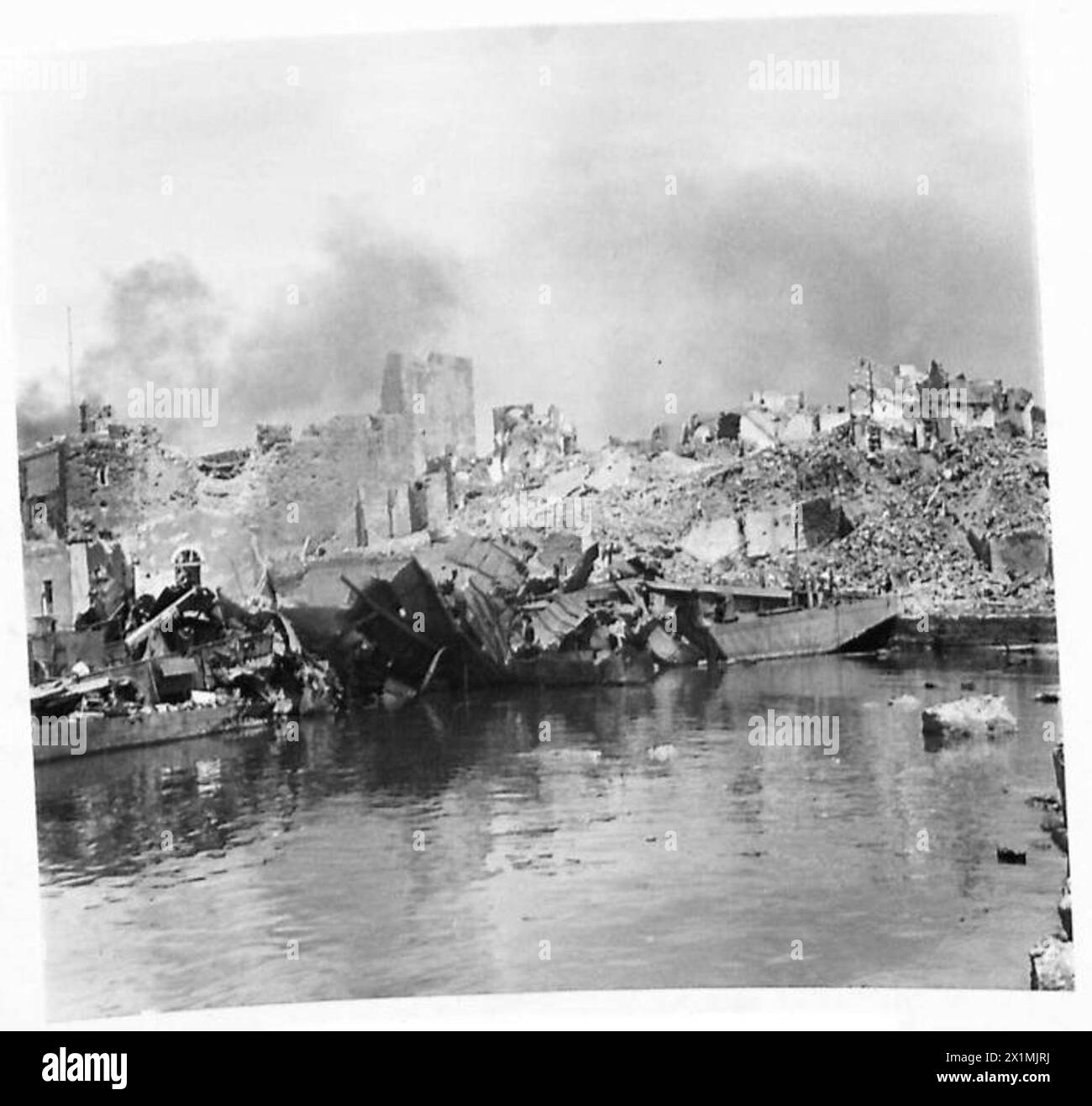 At the docks of Pantellaria, a burning enemy invasion barge is visible ...