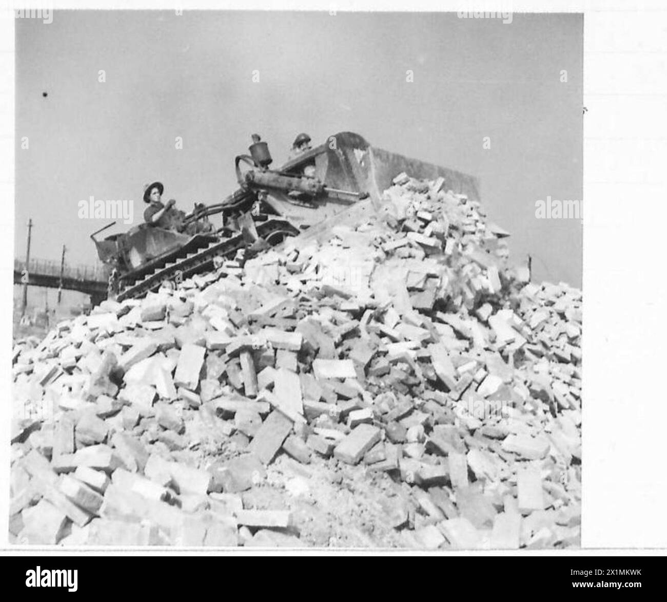 EIGHTH ARMY : VARIOUS - A bulldozer at work on the remains of shell and ...