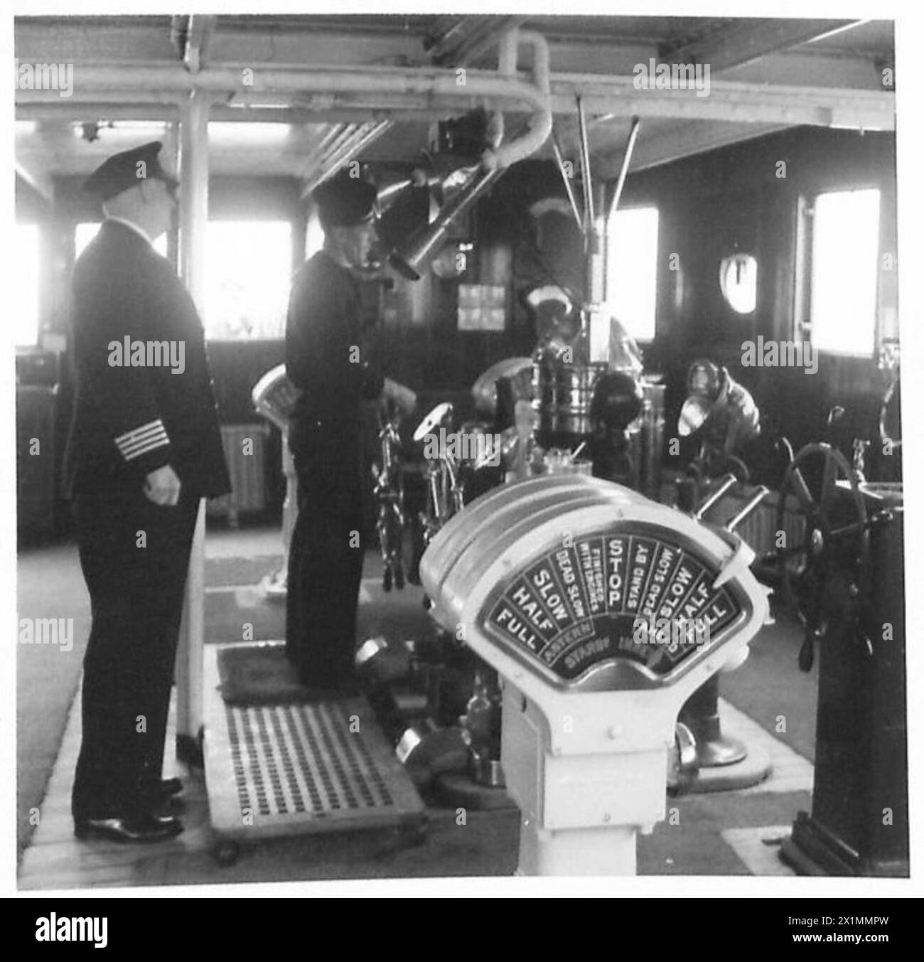 The captain of the troopship Queen Elizabeth is shown on the bridge ...