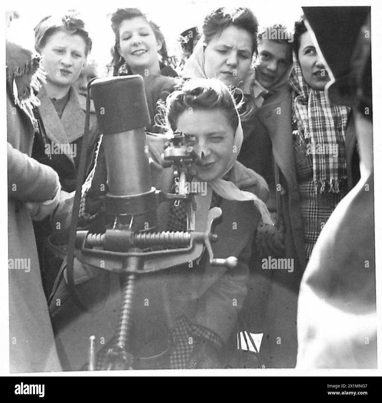 A female munition worker observes the sights of a 3-inch mortar during ...