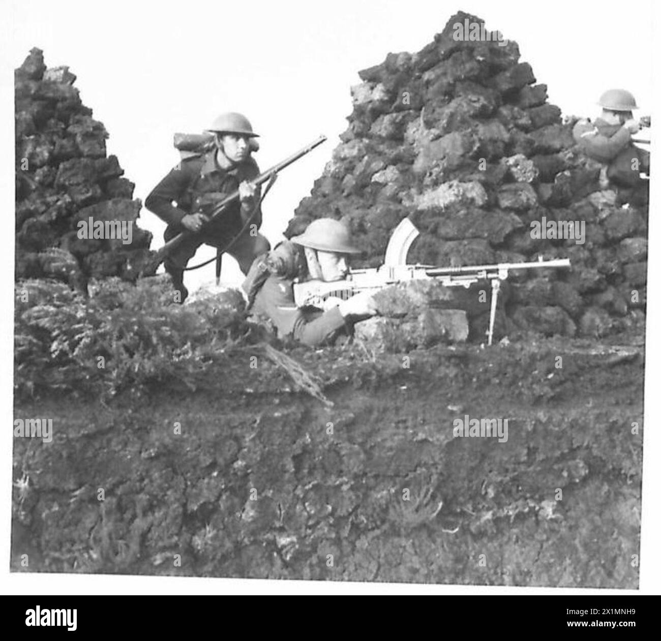 A sniper patrol takes cover among stacked peat in a Northern Ireland ...