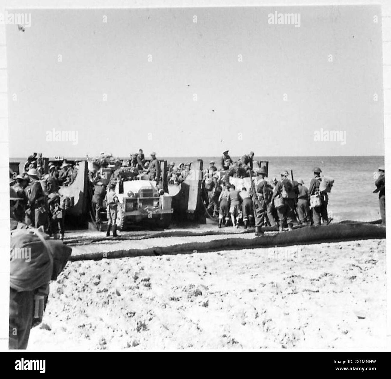 Motor transport vehicles are being driven off a Motor Landing Craft ...