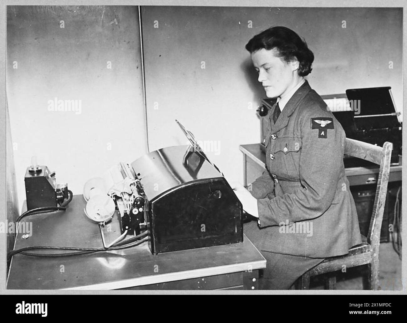 A WAAF teleprinter operator transmits messages from an RAF station in ...