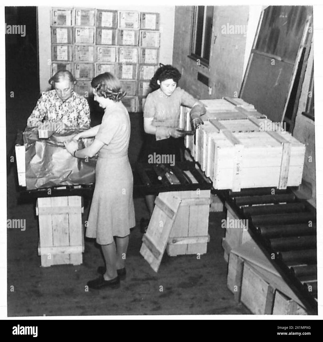 At the R.O.A.C. depot, cartons are packed into wooden crates, sealed ...