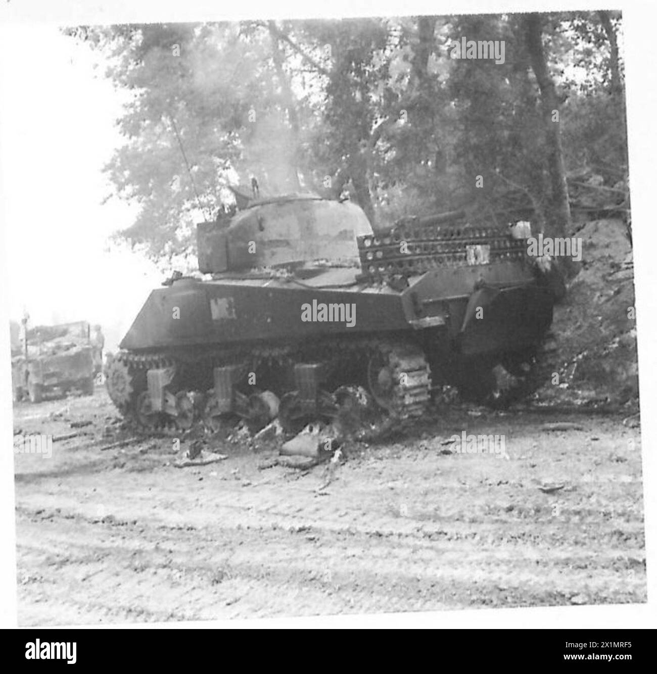 A Sherman tank is burning after being hit during an assault on the ...