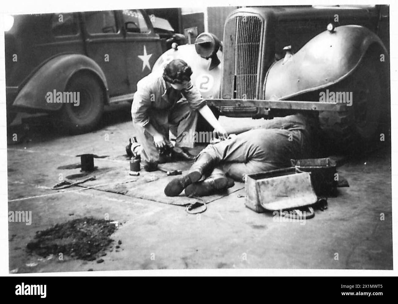 L/Cpl. Alison of the ATS assists a fellow member in vehicle maintenance ...