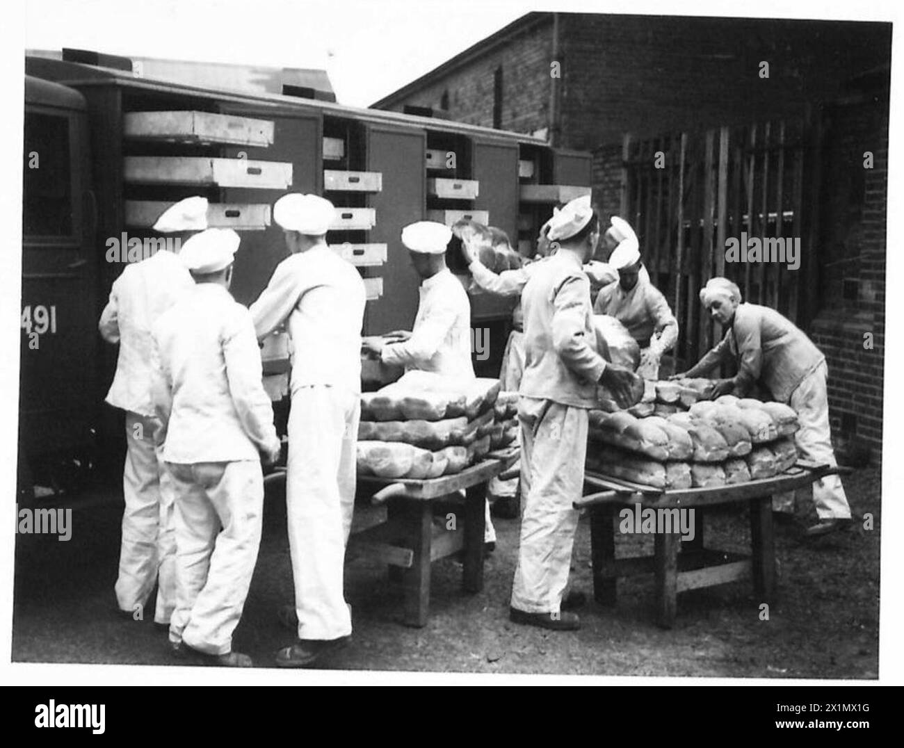 BAKING THE ARMY'S BREAD - Carrying out newly-baked loaves of bread for ...