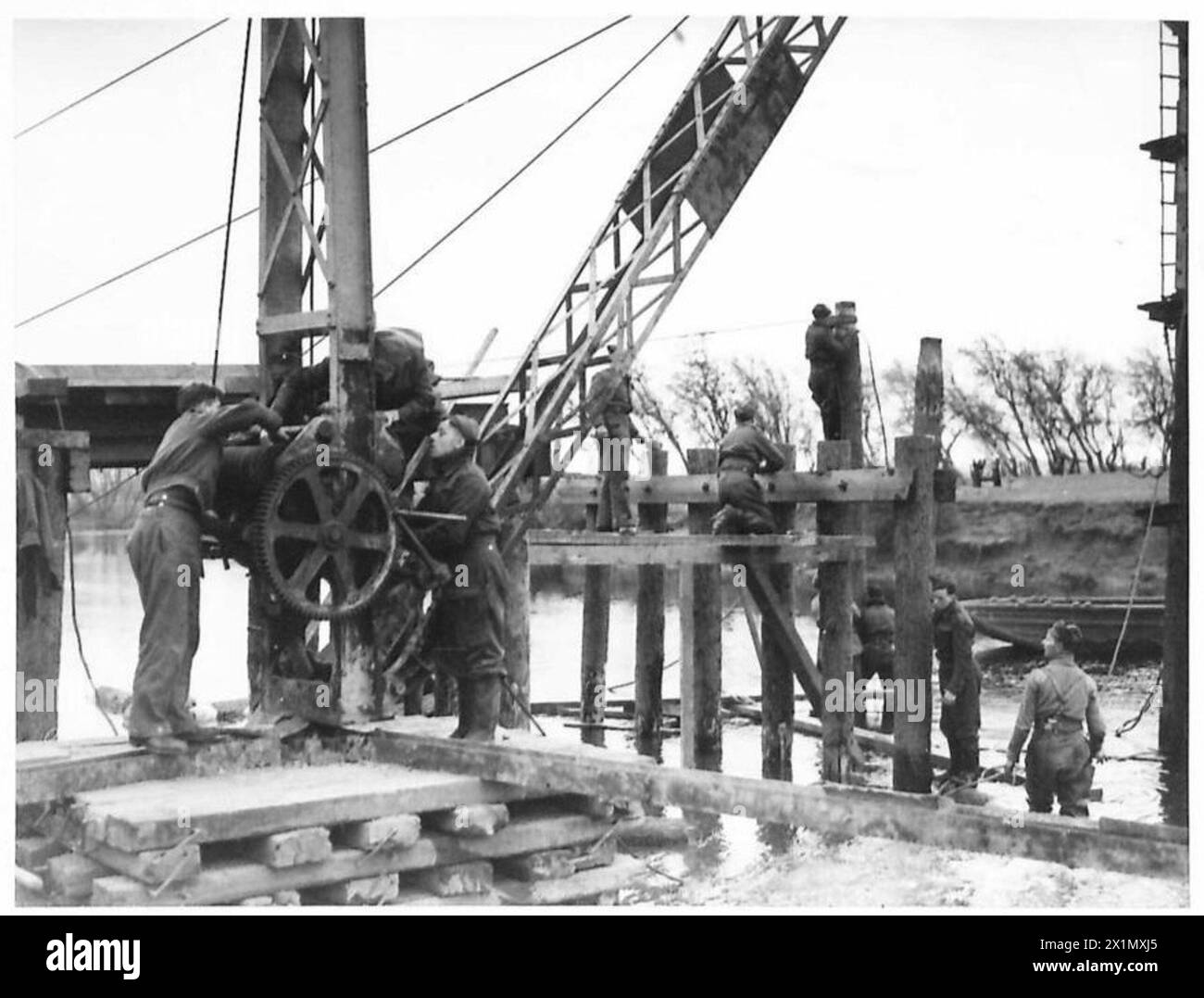 Royal Engineers construct a bridge using pile drivers, demonstrating ...