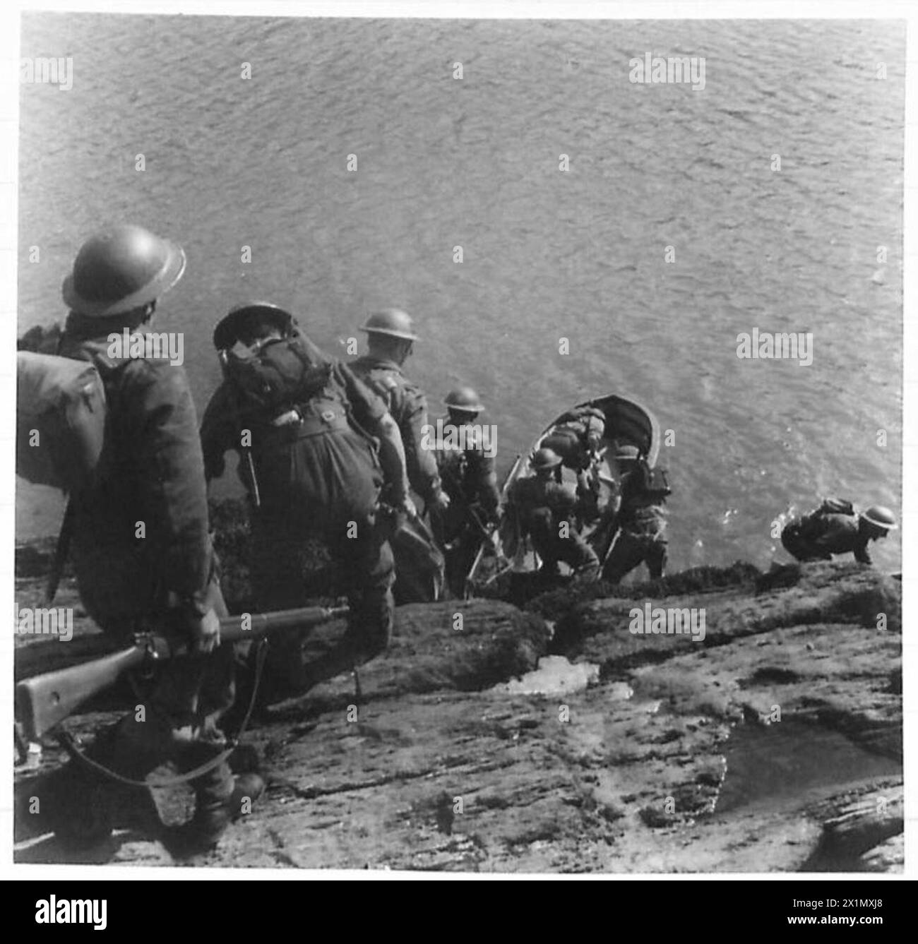 TOUGHENING-UP AT A WEAPON TRAINING SCHOOL - Troops descend the cliff ...
